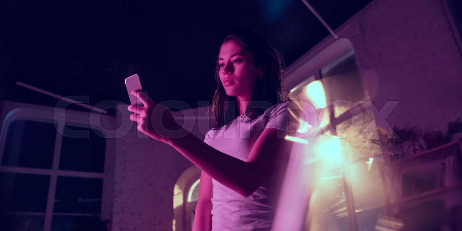 Cinematic portrait of handsome young woman in neon lighted interior ...