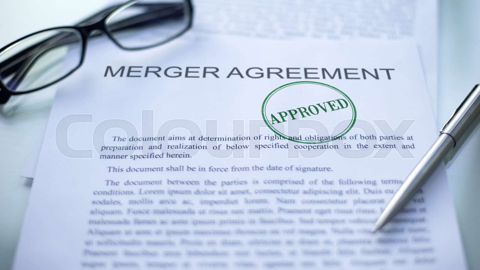 Merger agreement approved, seal stamped on official document, business ...