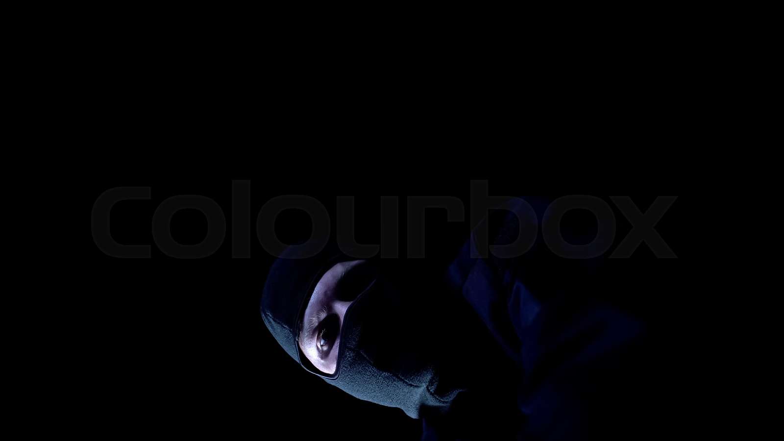 Serial killer in balaclava closing body bag with victim of murder ...