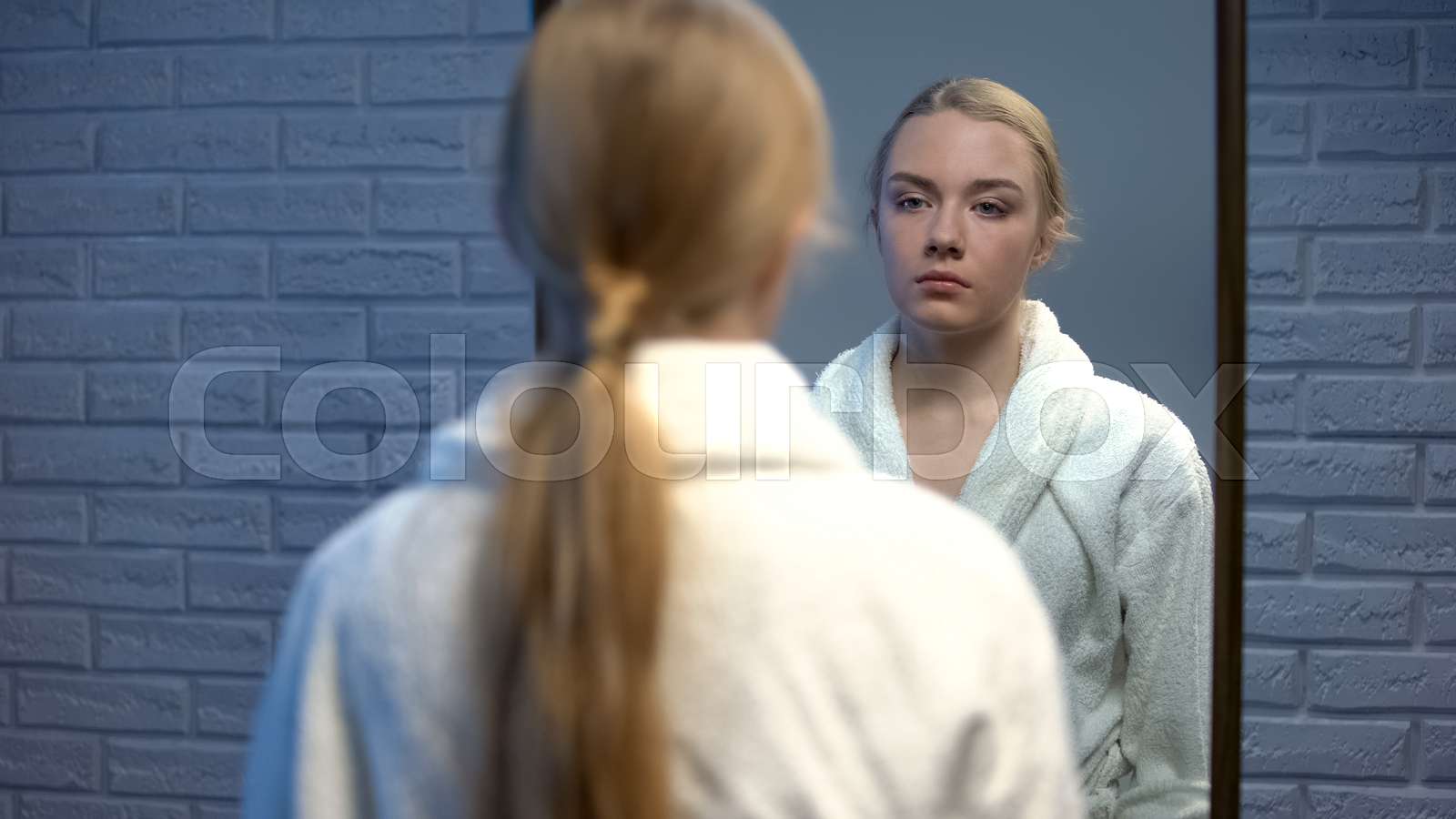 Unhappy young lady in bathrobe suffering stress looking in mirror, soul ...