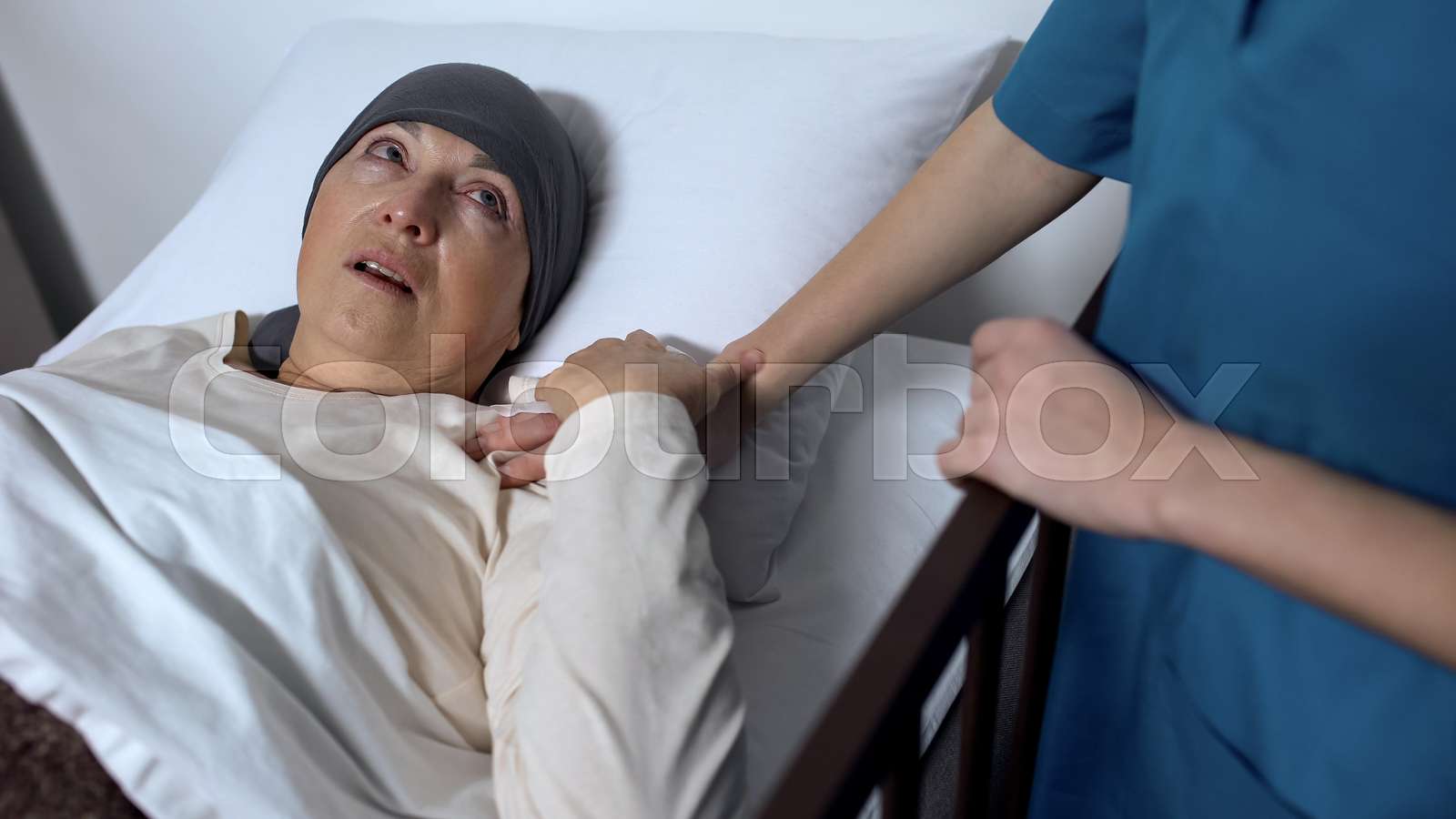 Physician supporting terminally ill lonely female patient, holding ...