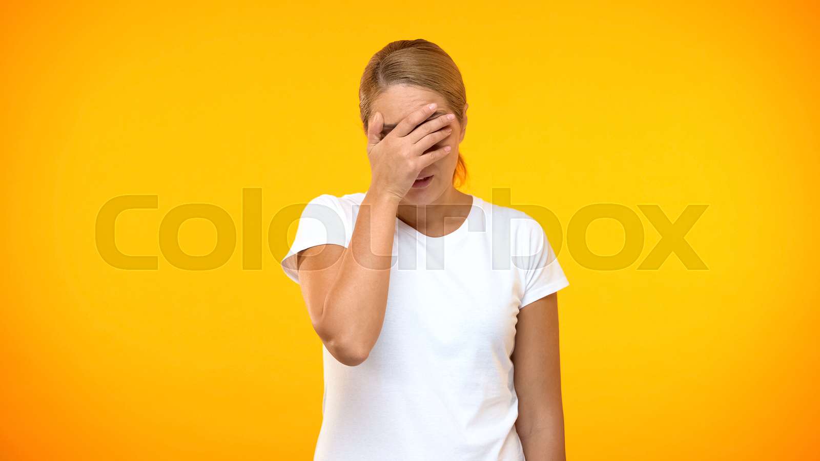 Stressed woman showing face palm gesture, covering eyes by hands ...