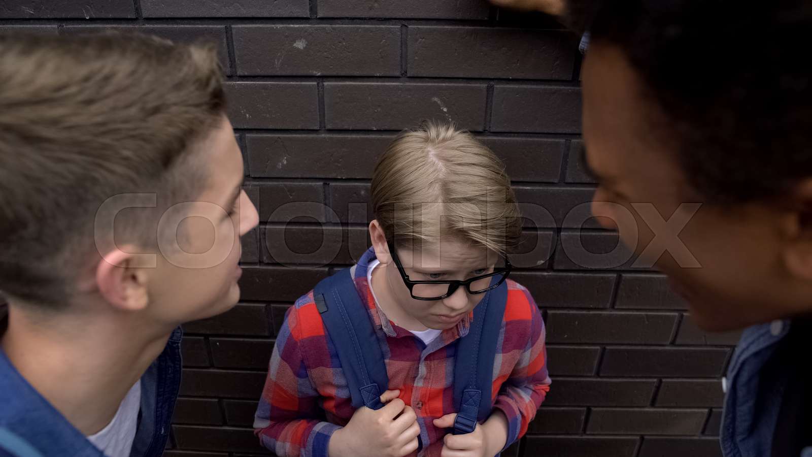 Tall students bullying junior boy, teasing about small stature ...