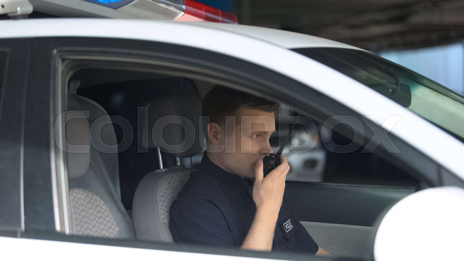 Police officer in car using walkie-talkie, dispatcher informing about ...