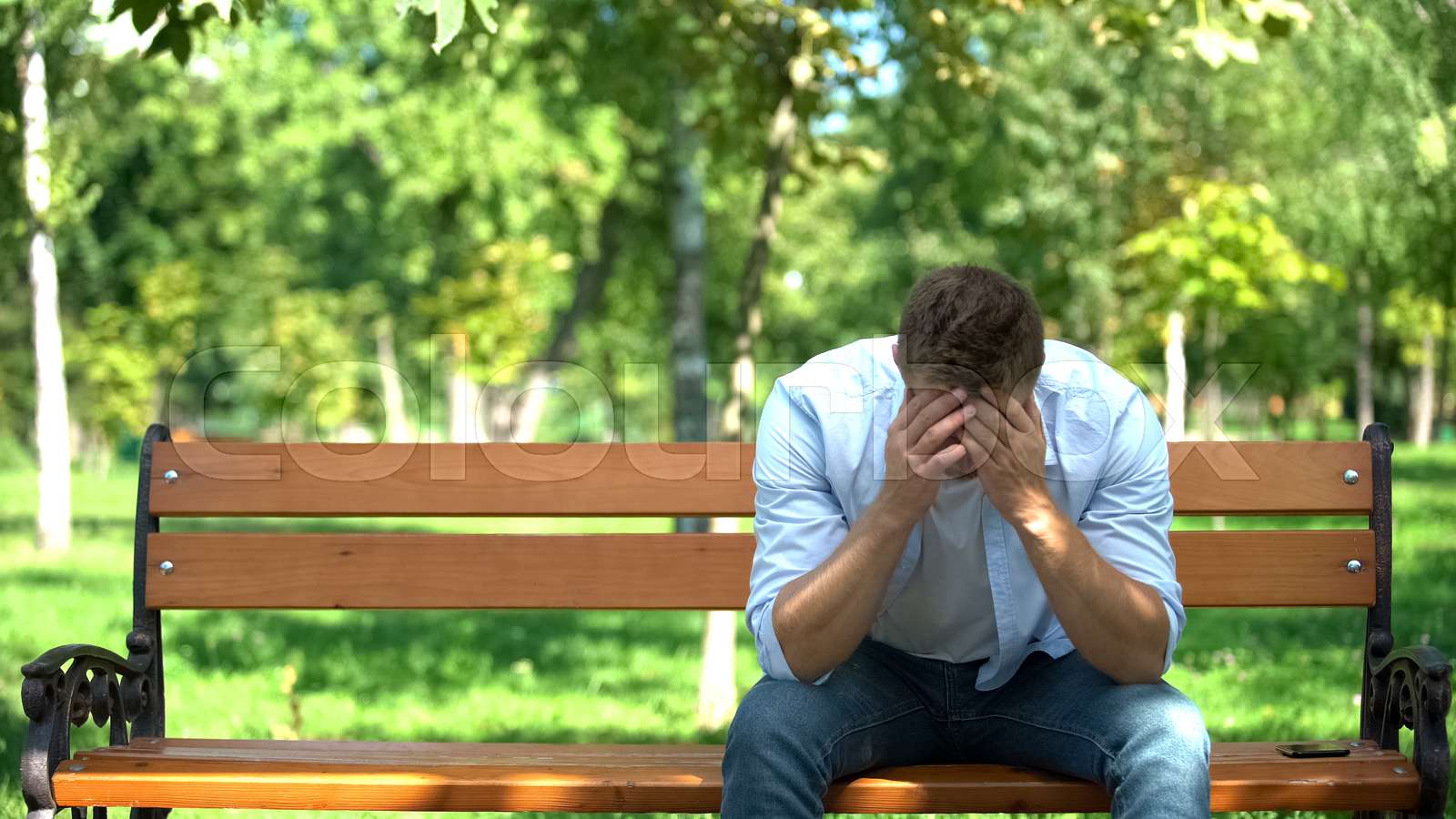 Depressed young man sitting alone bench thinking problem, broken heart ...