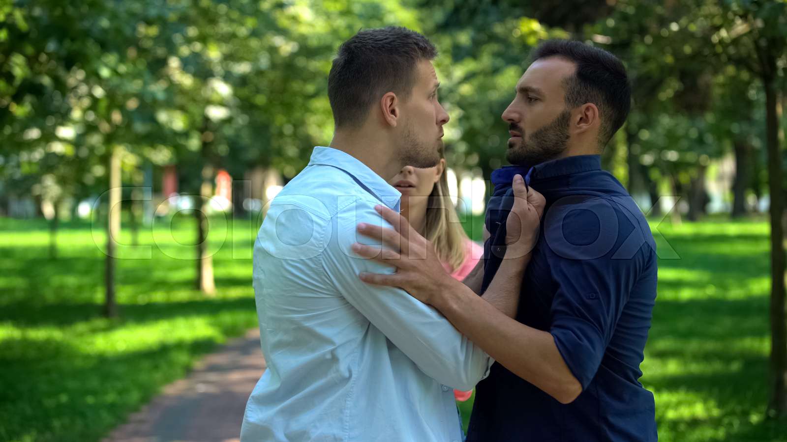 Aggressive men fighting outdoors, scared girlfriend trying calm down ...