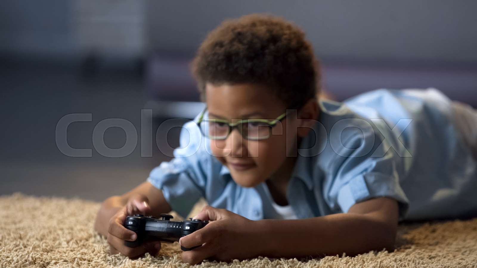 Boy looking at screen while playing video game, health harm, sedentary ...