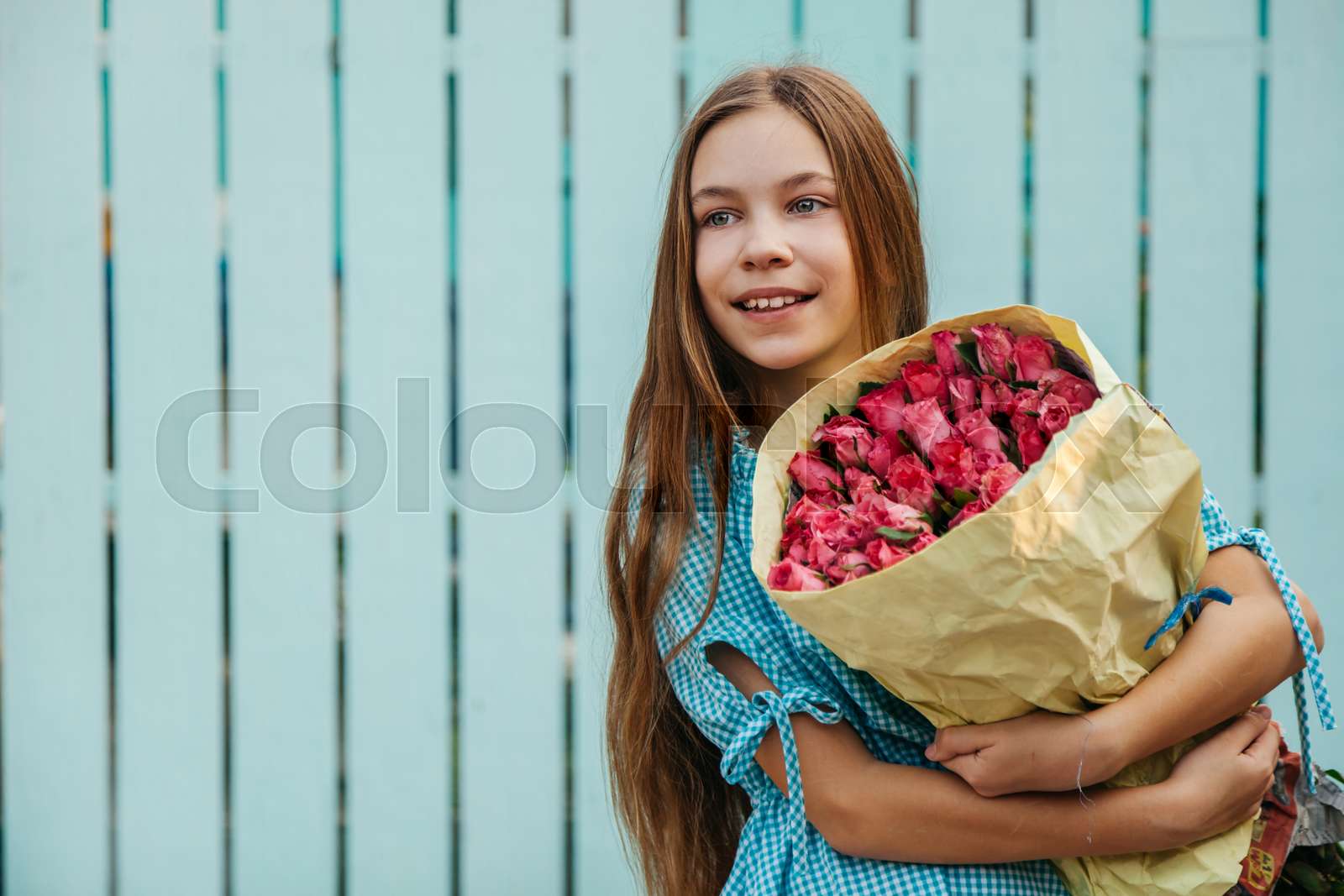 Tween girl holding bunch of roses | Stock image | Colourbox