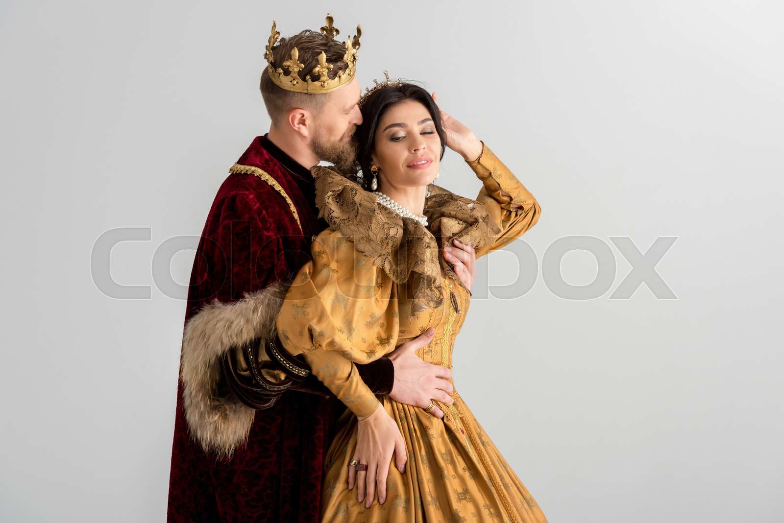 king with crown kissing and hugging smiling queen isolated on grey ...