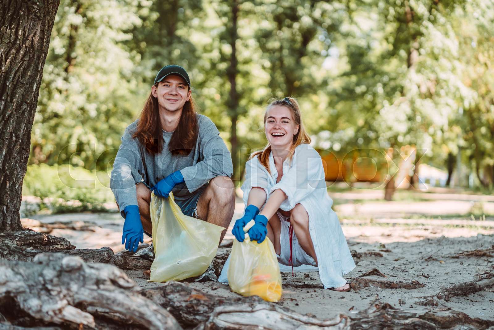 Man and Woman picking up trash from the park. They collecting the ...