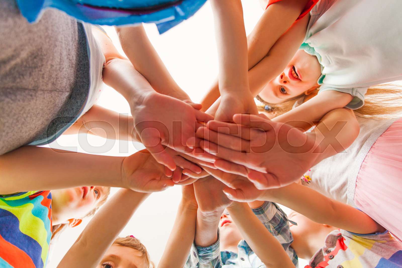 Happy children holding their arms together close up | Stock image ...