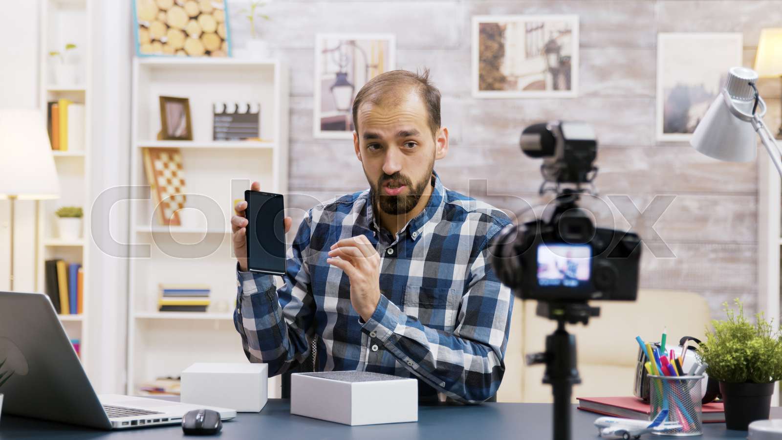 Famous young influencer recording the unboxing of a phone | Stock image ...
