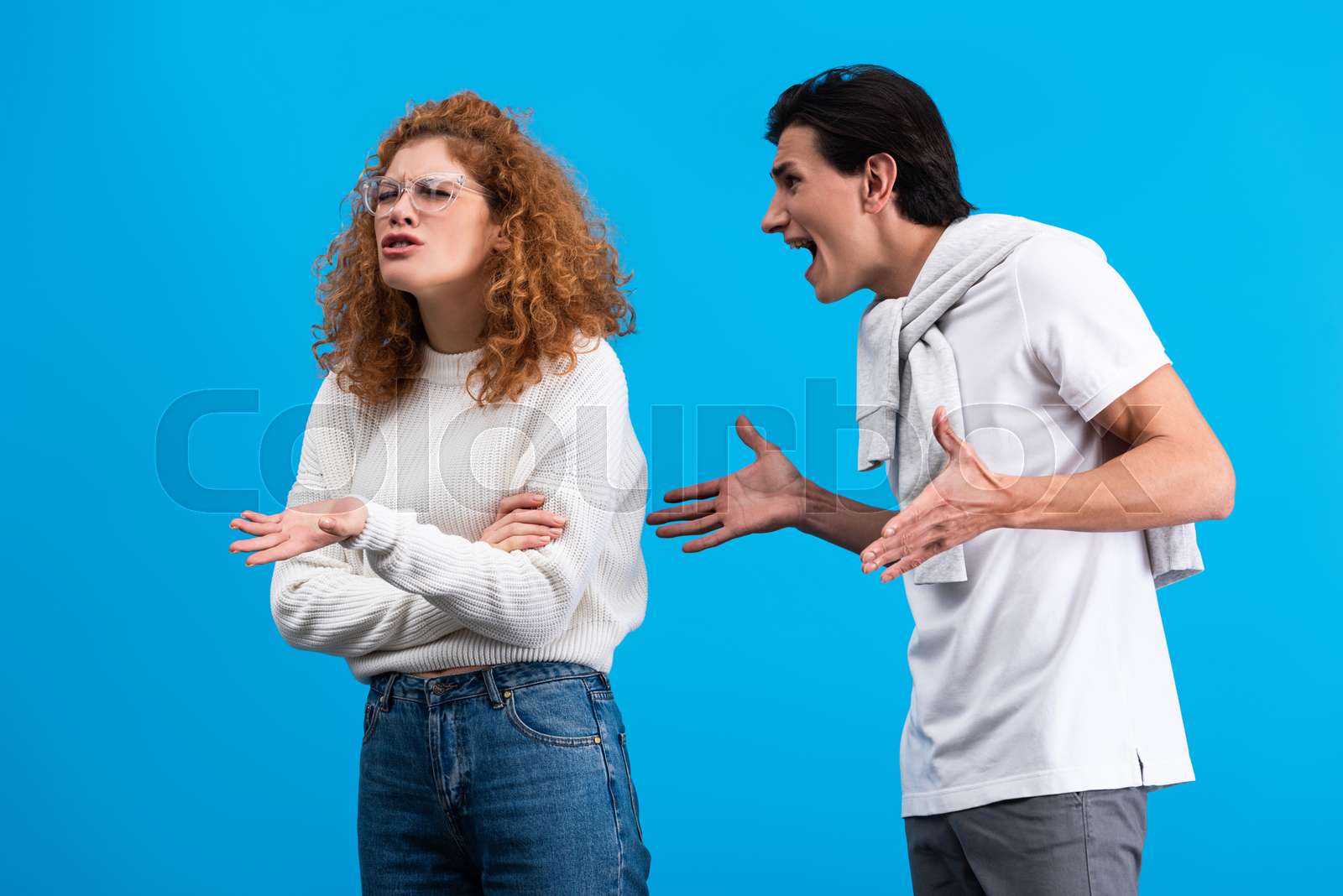 angry boyfriend yelling at irritated girlfriend, isolated on blue ...