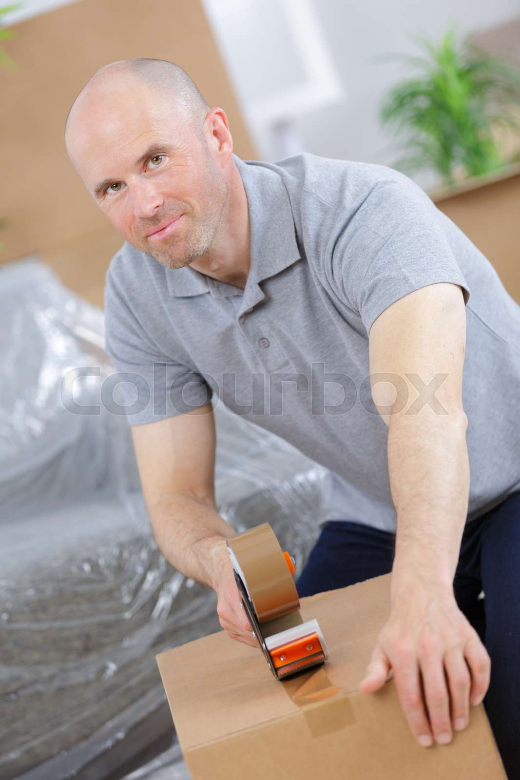 man taping a box while doing packing | Stock image | Colourbox