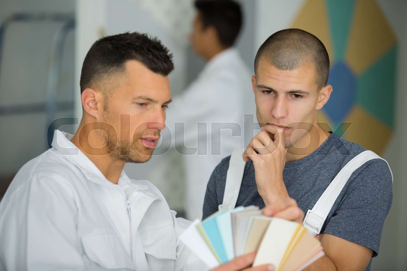 painter giving advice to commercial painting apprentice | Stock image ...