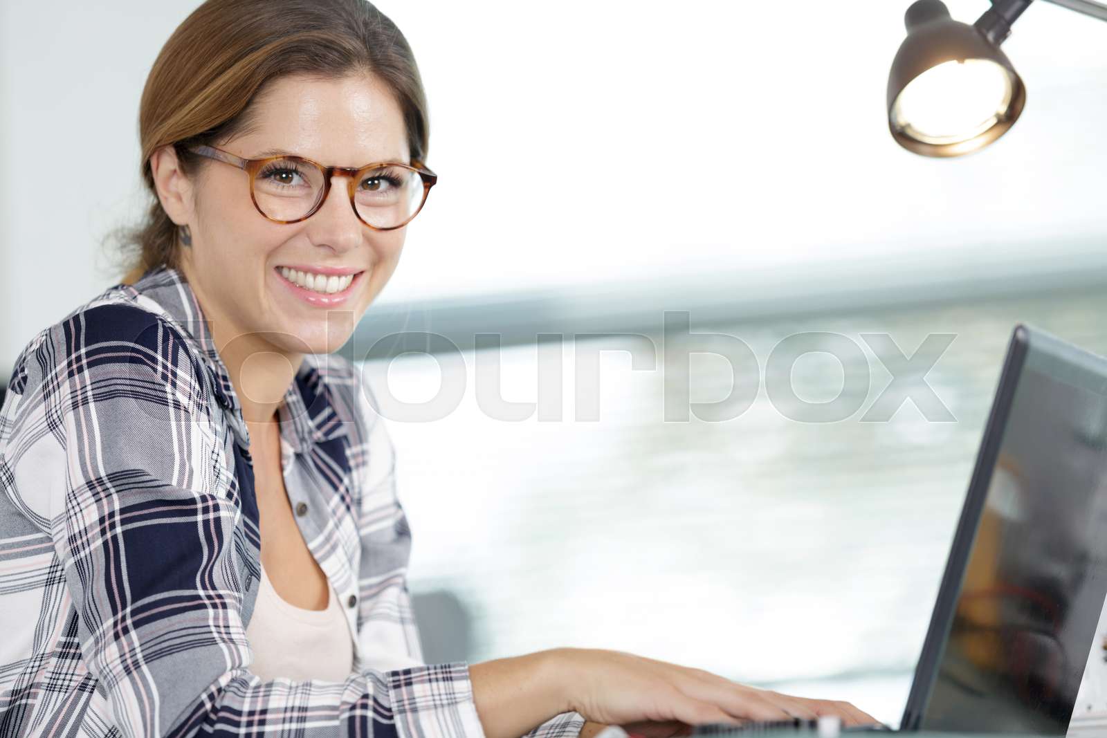 young lady wearing eyeglasses using laptop | Stock image | Colourbox