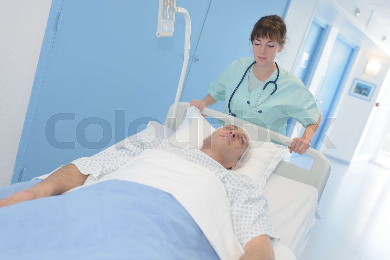 Nurse pushing patient in his bed | Stock image | Colourbox