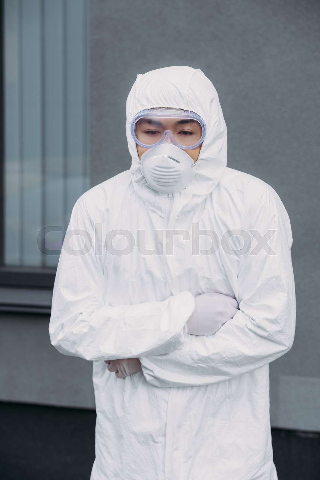 asian epidemiologist in hazmat suit and respirator mask standing with ...