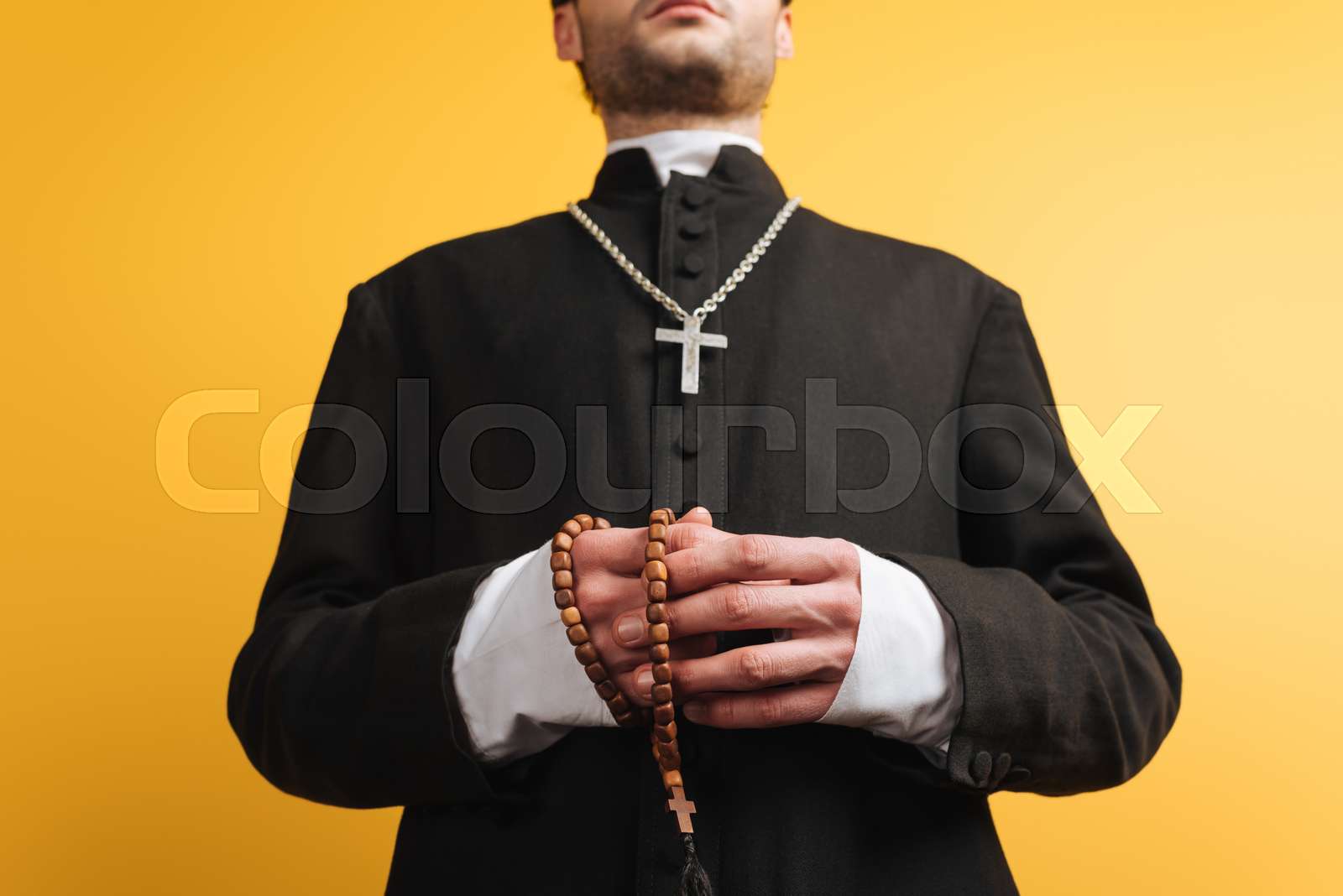low angle view of catholic priest holding wooden rosary beads isolated ...