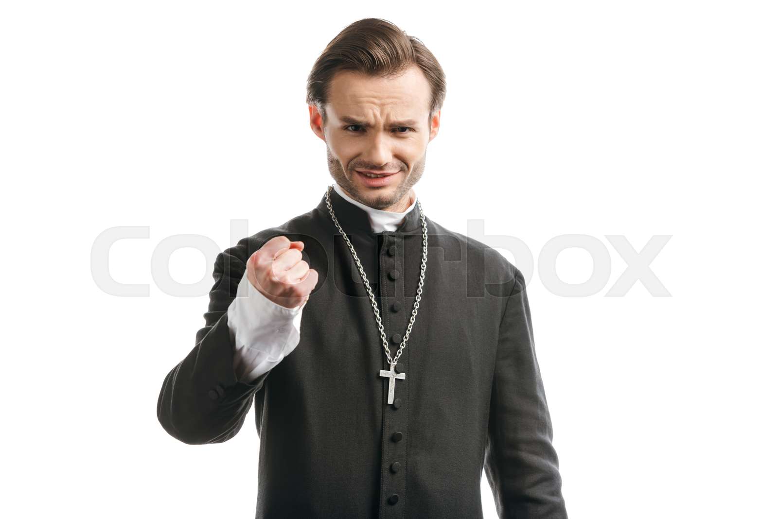 aggressive catholic priest showing fist while looking at camera ...