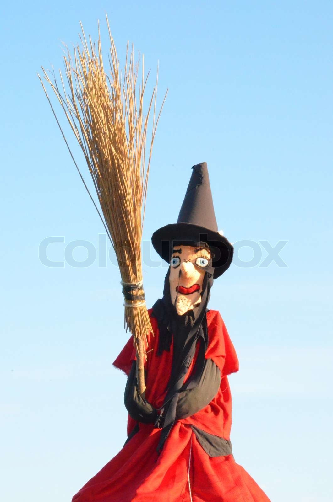 heks i rød kjole med kost på sankt hans bål | Stock foto | Colourbox