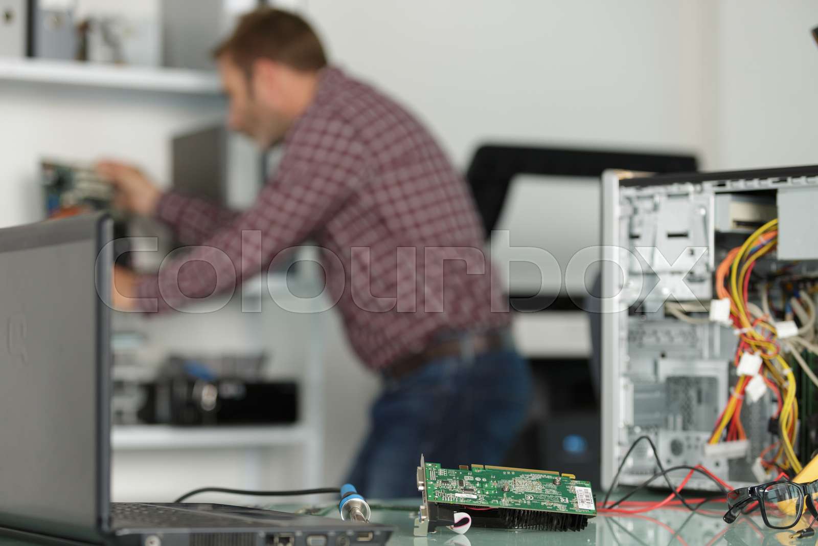 frustrated young man fixing a pc | Stock image | Colourbox