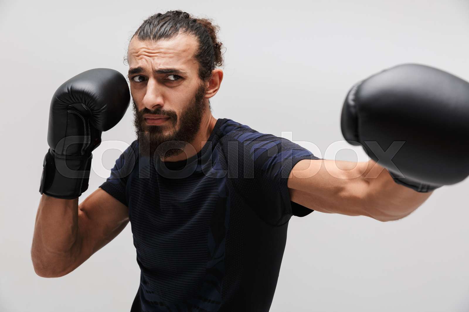 Image of serious muscular sportsman wearing tracksuit boxing in gloves ...