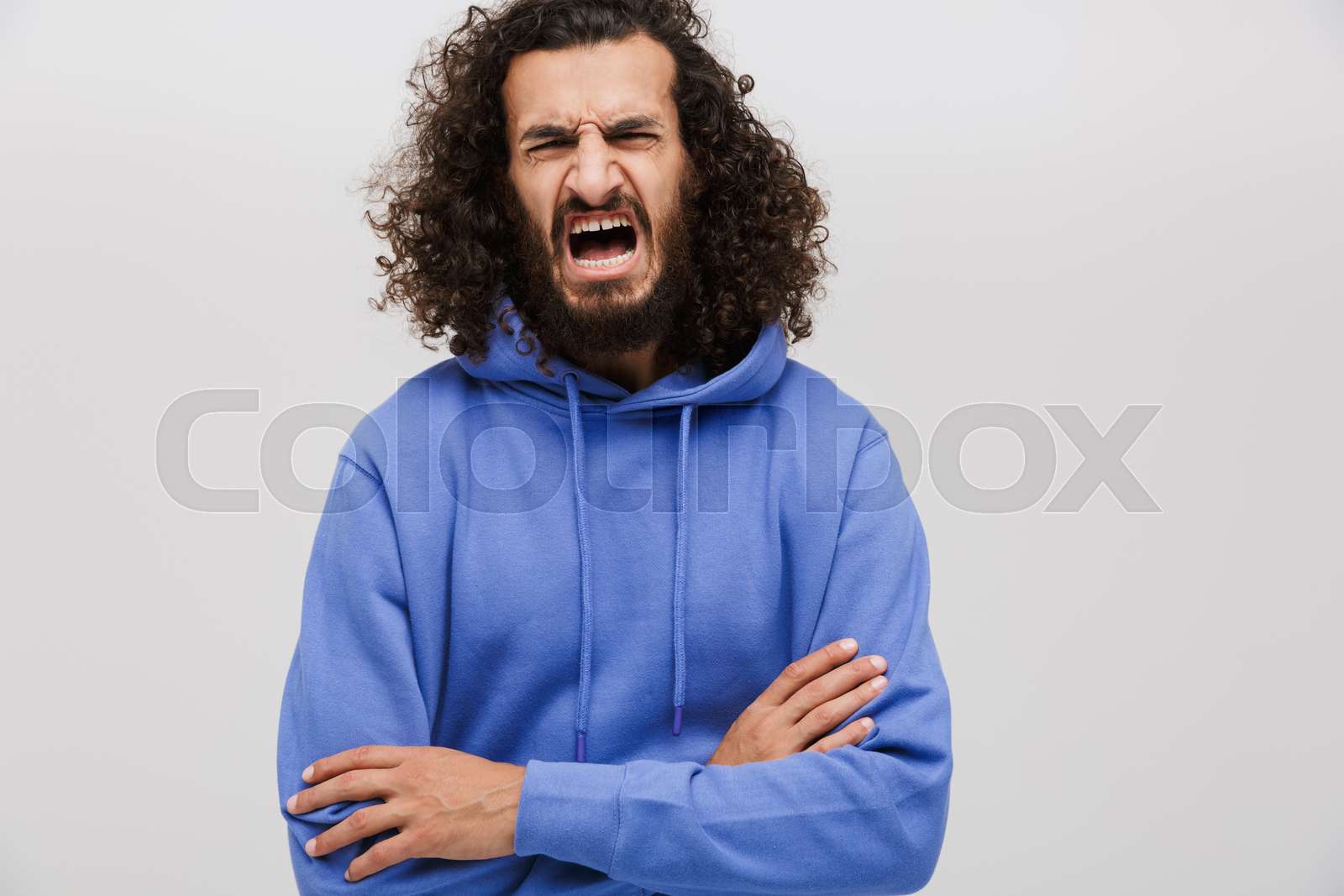 Image of stressed unshaven man screaming and standing with arms crossed ...