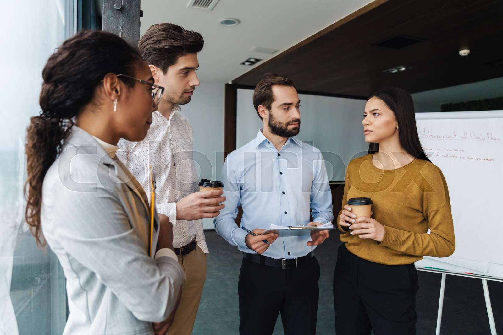 Portrait of young successful multinational colleagues working in office ...