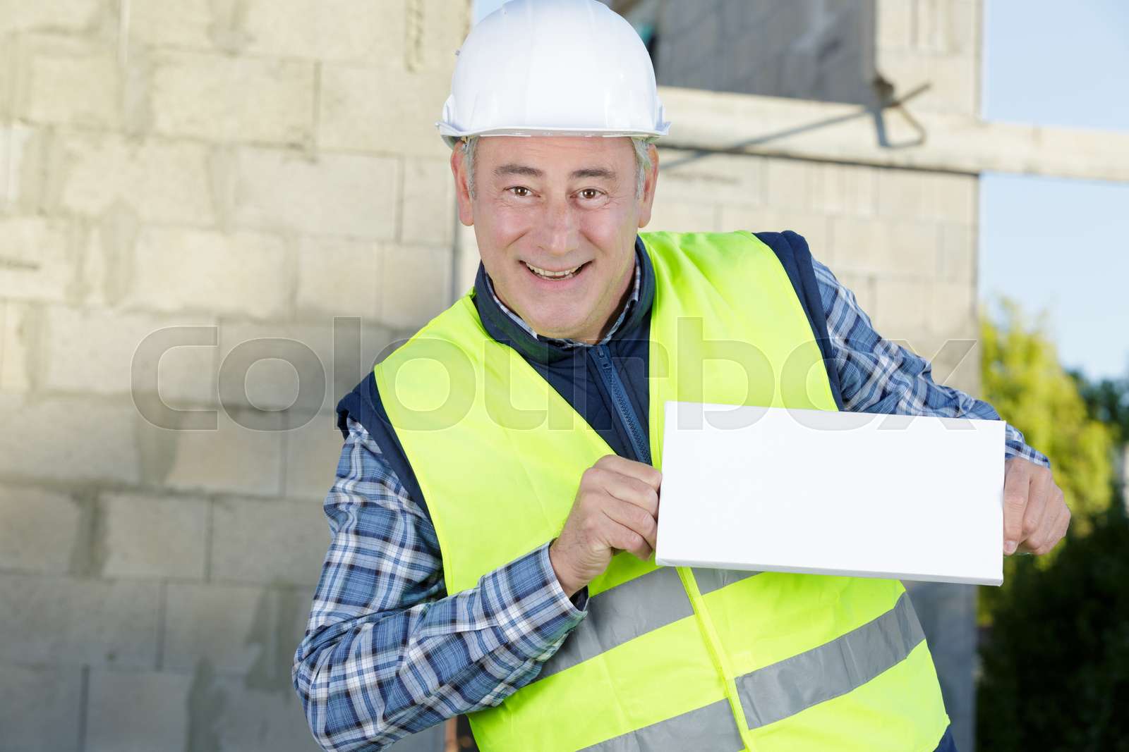 happy builder showing a sign | Stock image | Colourbox