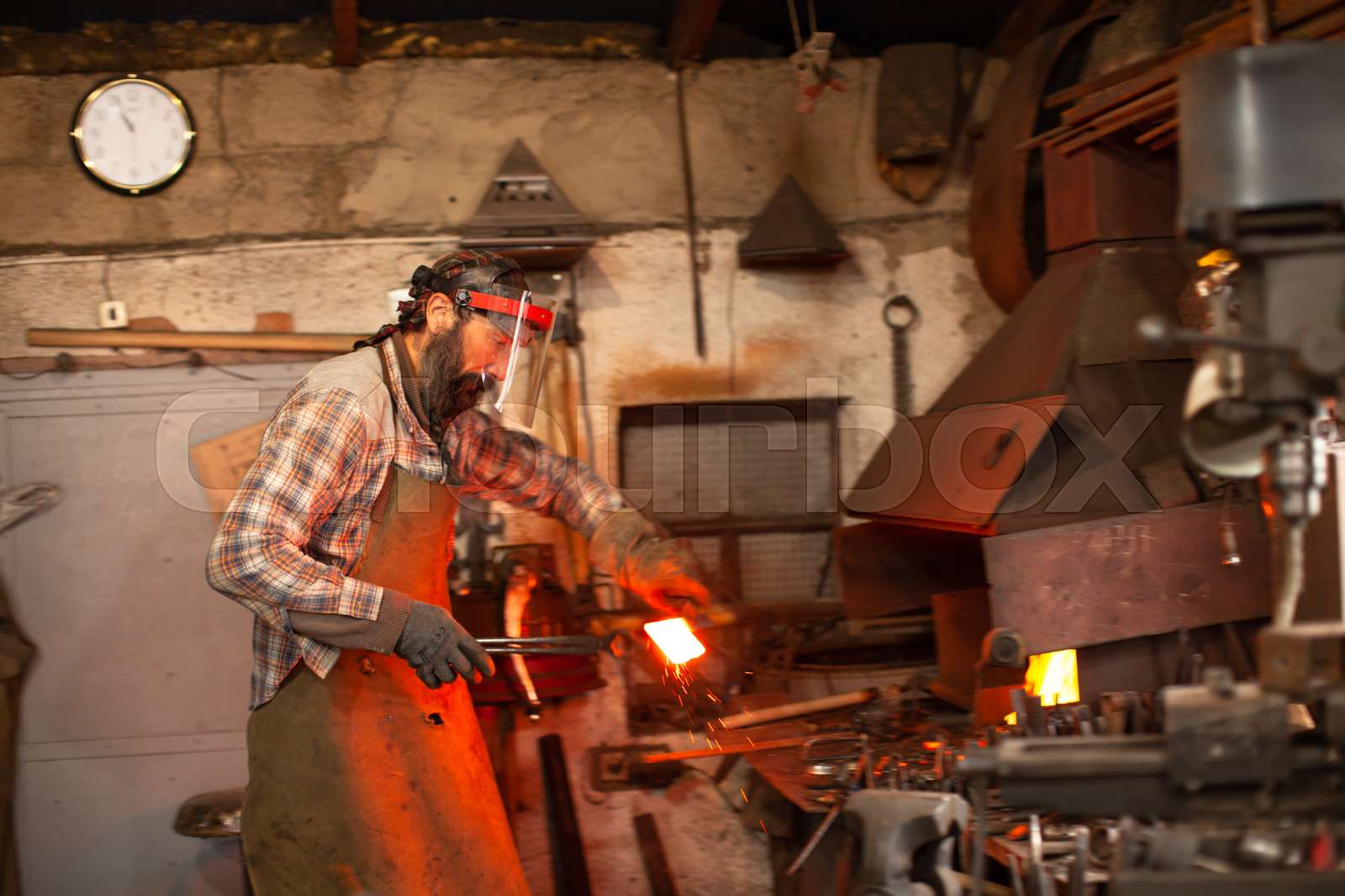 Real brutal blacksmith works in a workshop with a red-hot iron. | Stock ...
