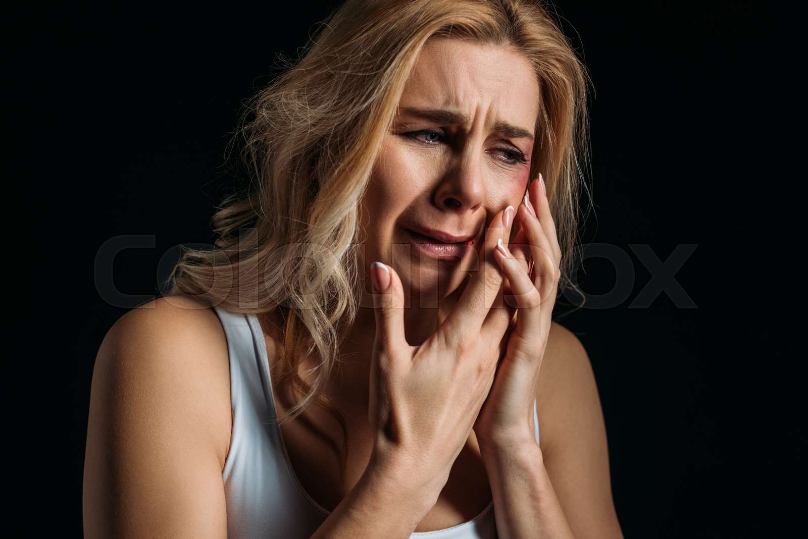 Woman crying and touching face with bruise isolated on black | Stock ...