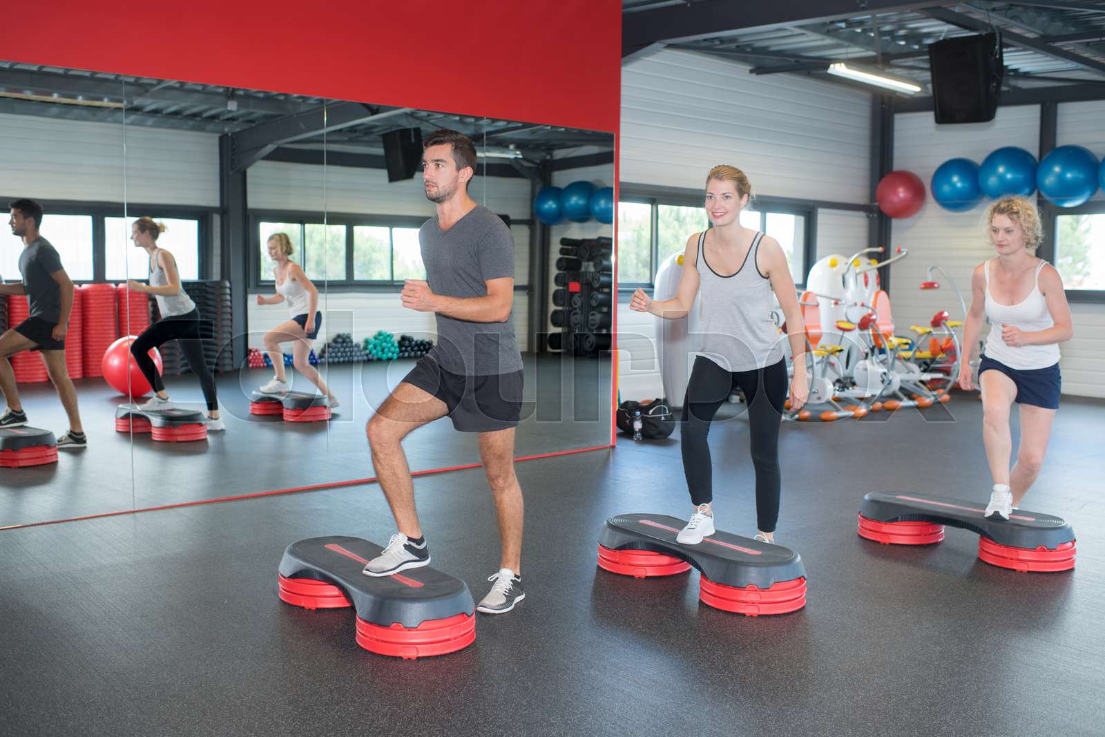 group of people flexing legs on step platforms | Stock image | Colourbox