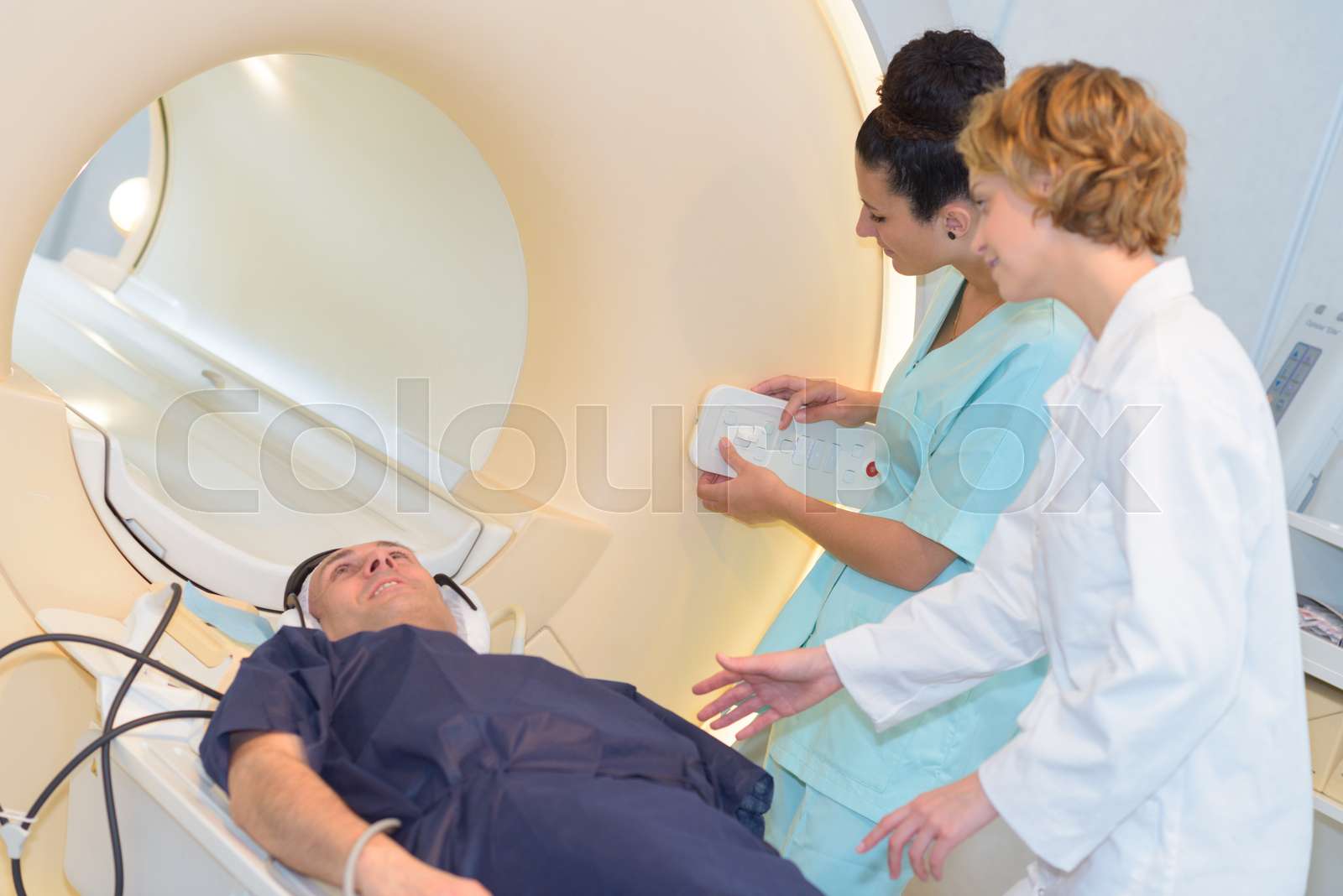 nurses reassuring patient as he enters mri scanner | Stock image ...