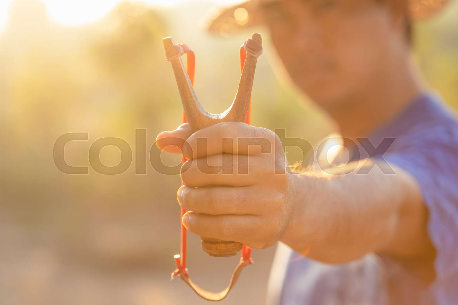 Man playing slingshot or catapult in morning time with sunlight effect ...