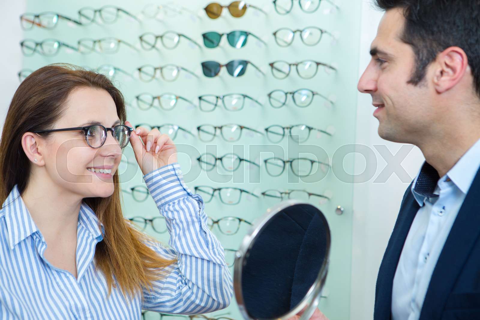 woman checking glasses in mirror | Stock image | Colourbox