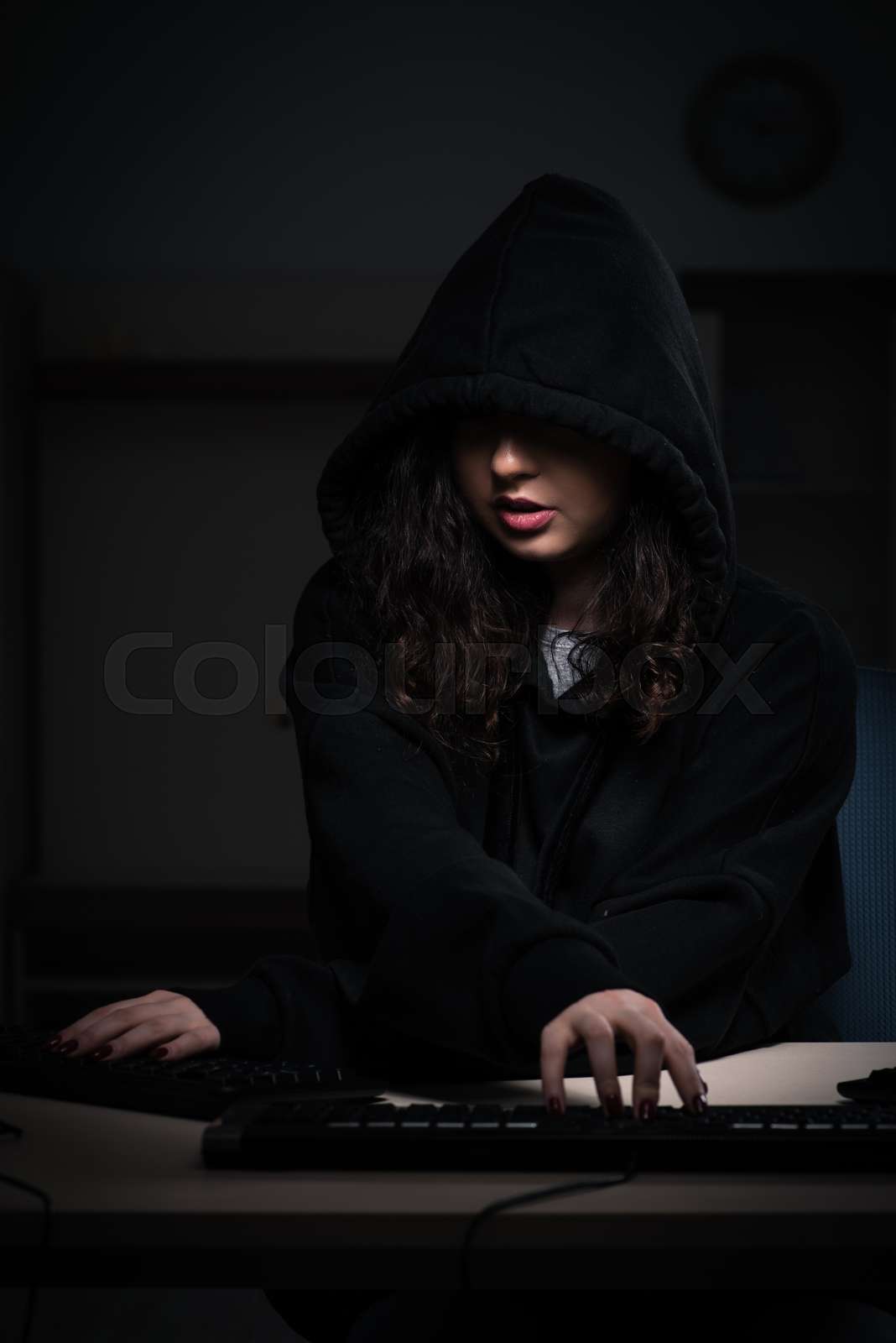 Female hacker hacking security firewall late in office | Stock image | Colourbox