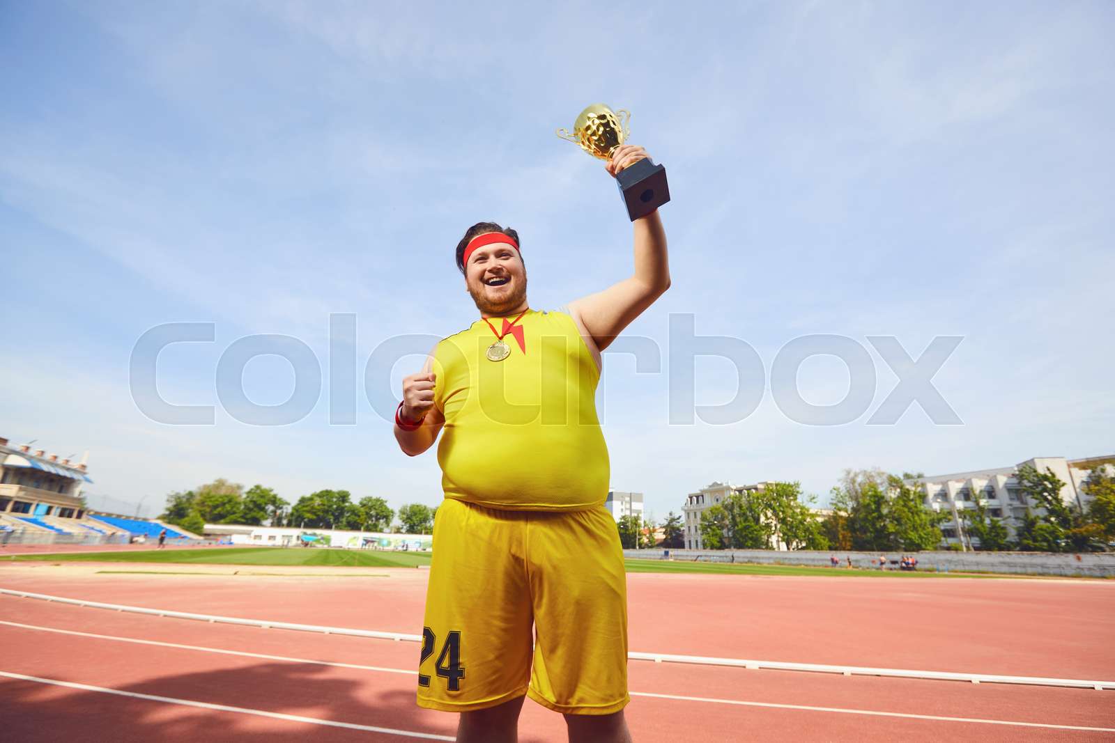 A fat man with a winner's cup in his hands at the stadium. | Stock ...