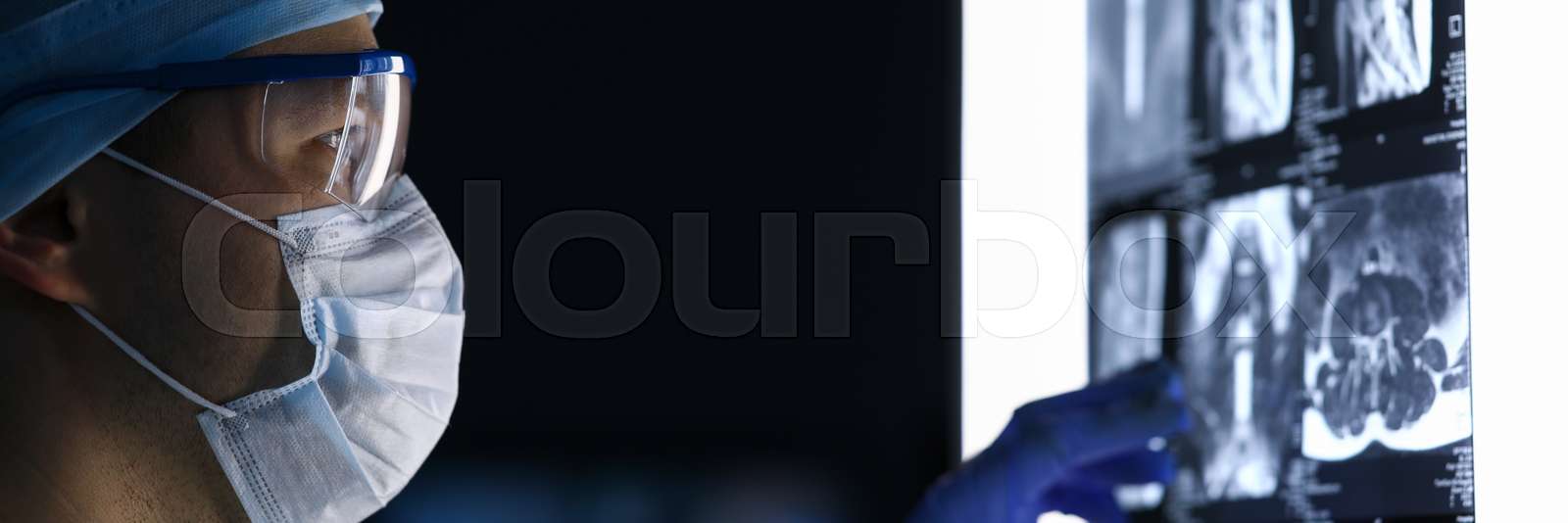 Male doctor in surgical clothes looking at vertebral mri scan | Stock ...