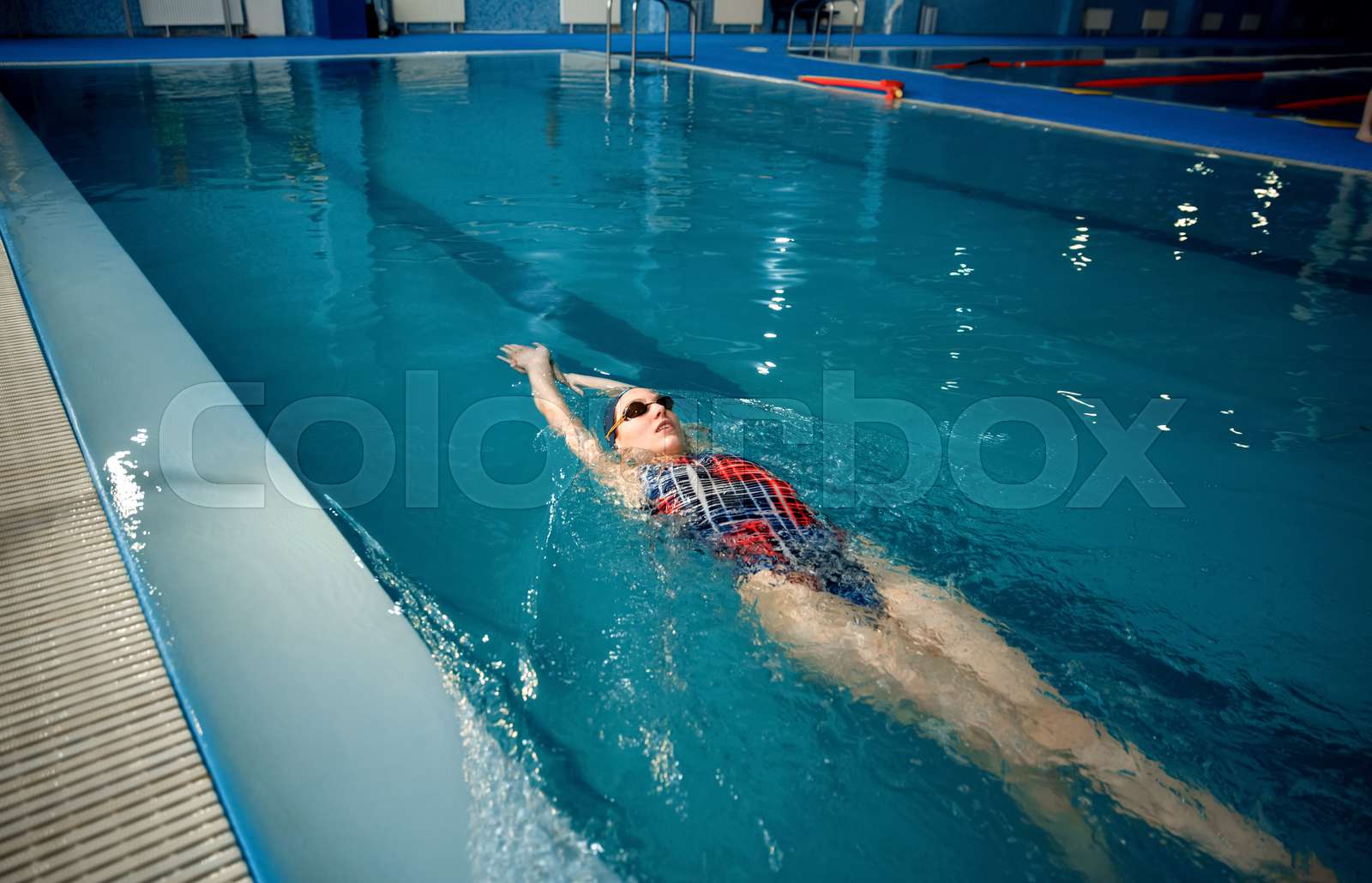 Female swimmer swimming on her back in pool | Stock image | Colourbox