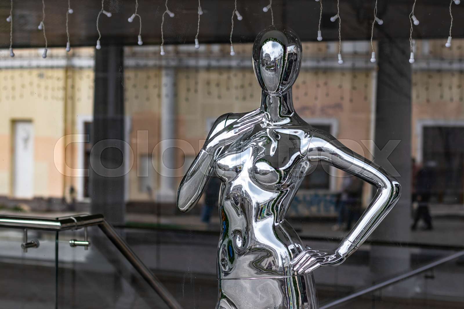 Silver mannequin standing in a shop window | Stock image | Colourbox