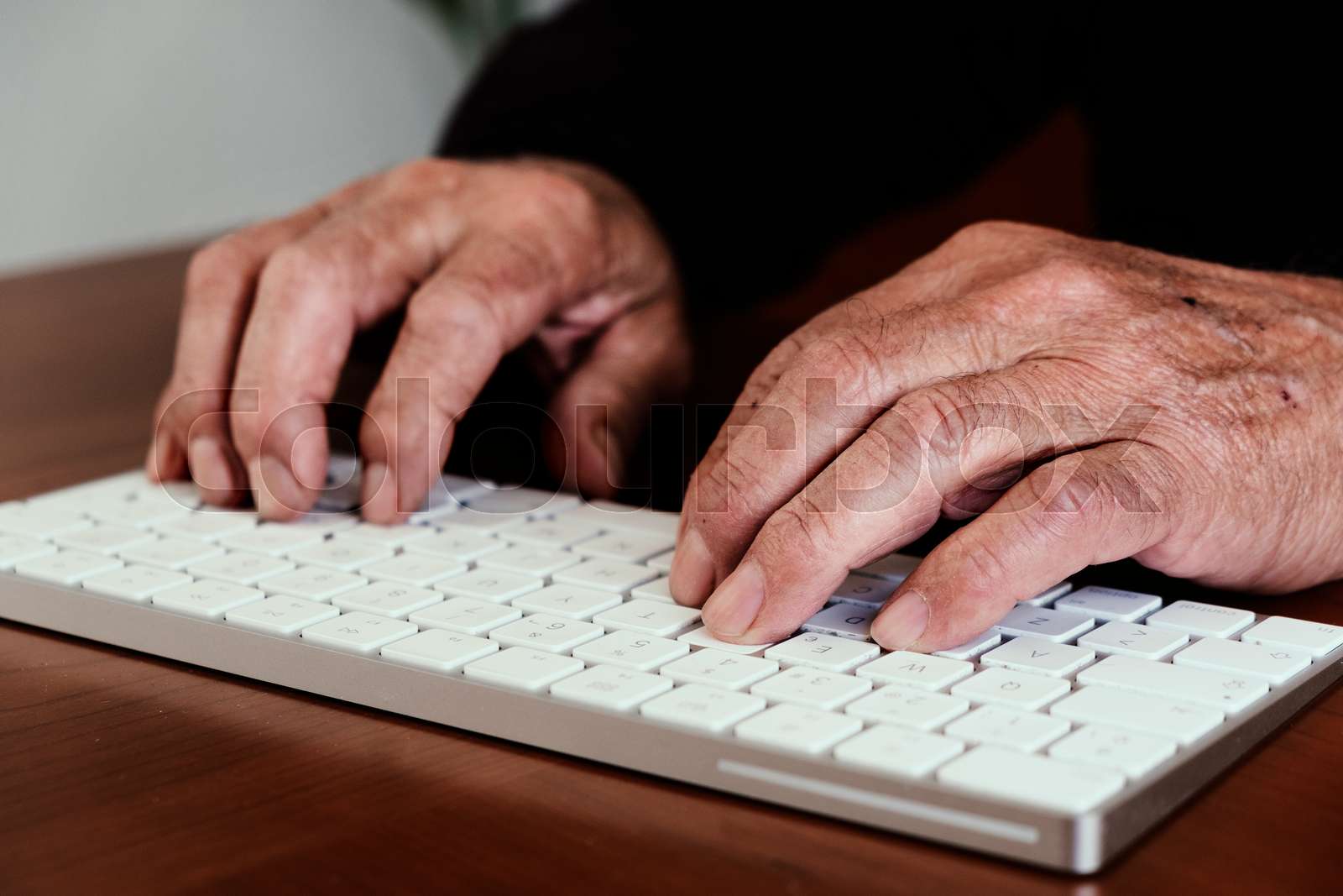 senior man typing in a keyboard | Stock image | Colourbox