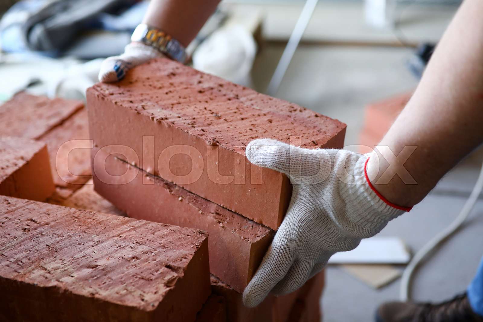Male hands lifting several red bricks at construction site | Stock ...