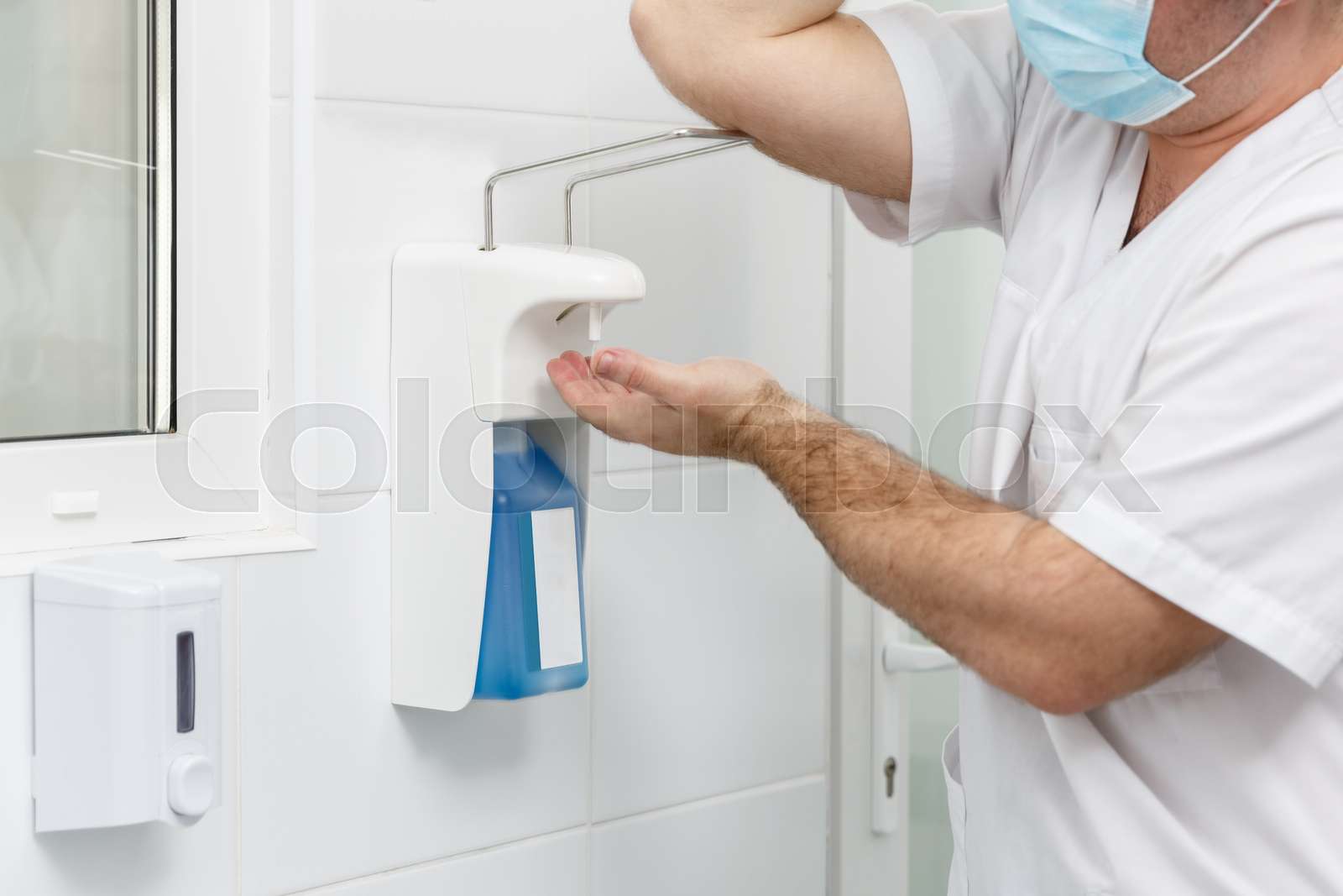 Doctor washing hands using disinfecting liquids in a surgical clinic ...