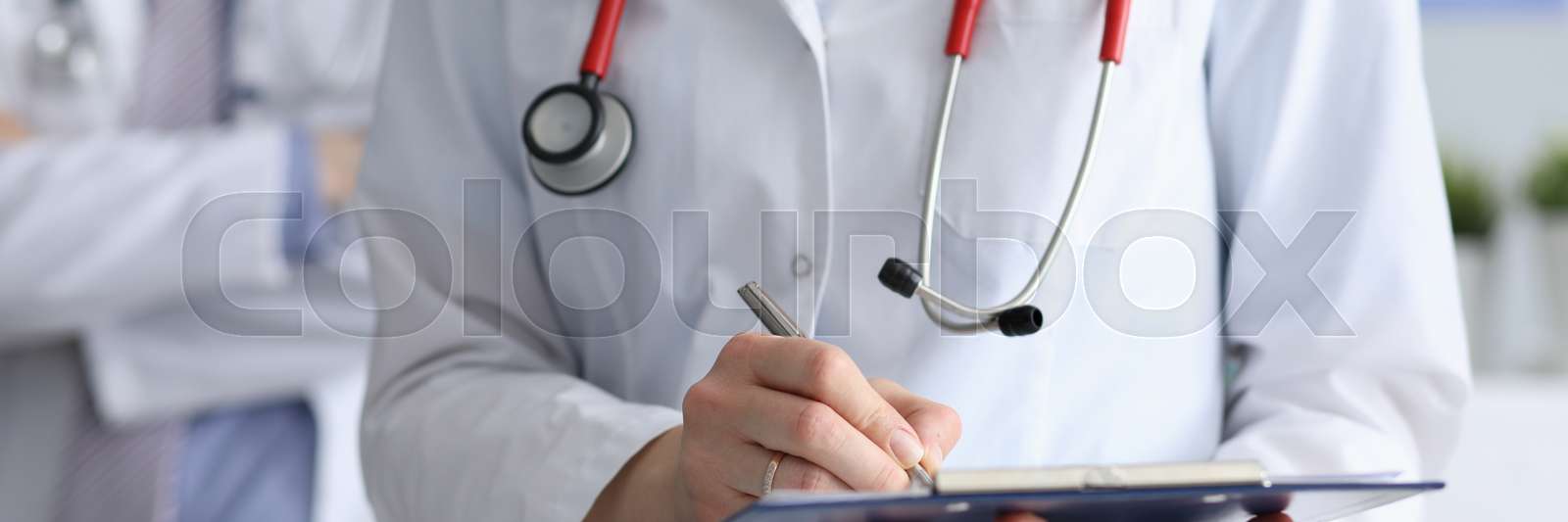 Doctor signing documents | Stock image | Colourbox