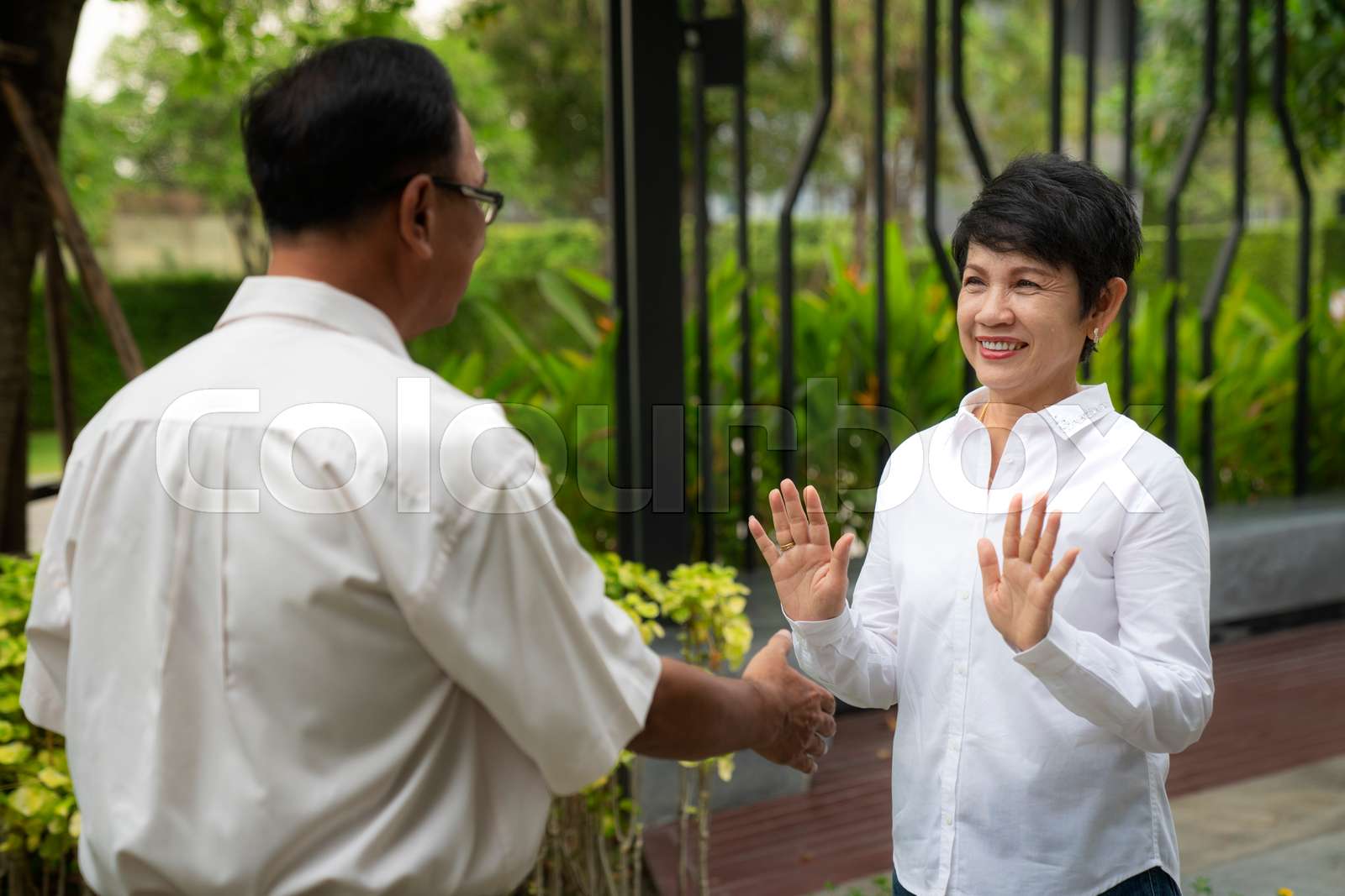 Old asian people no greeting by shakehands togather and use a mask for ...
