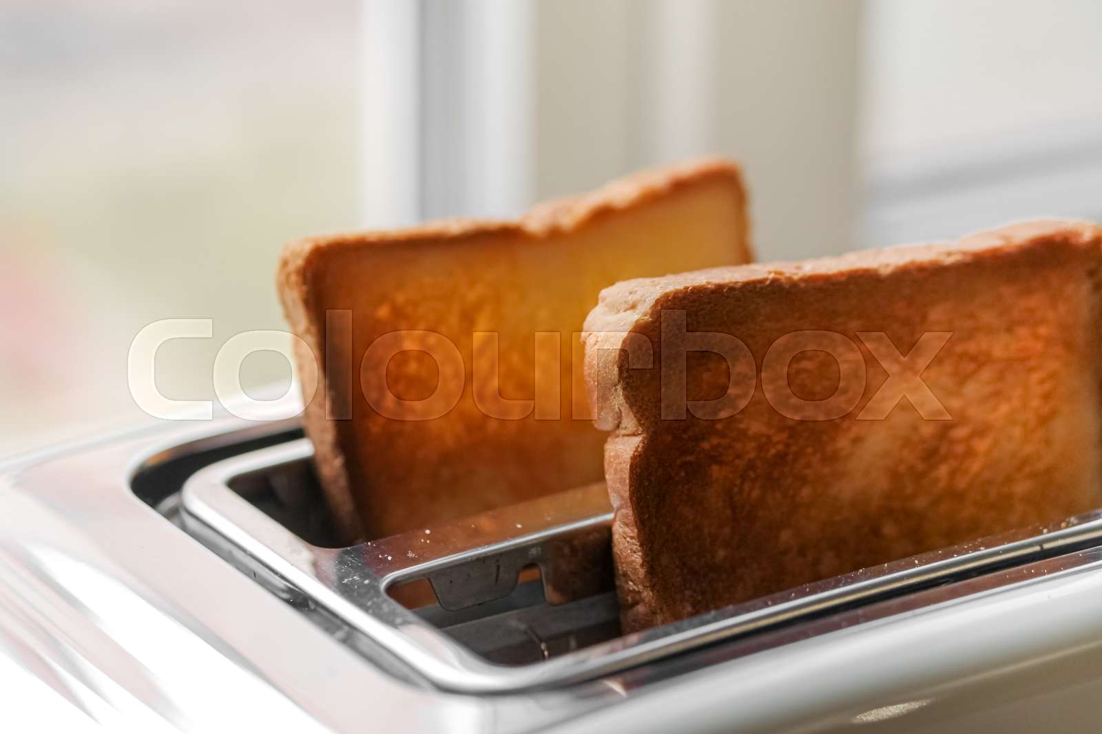 Toaster with ready bread slices in the kitchen. traditional breakfast ...