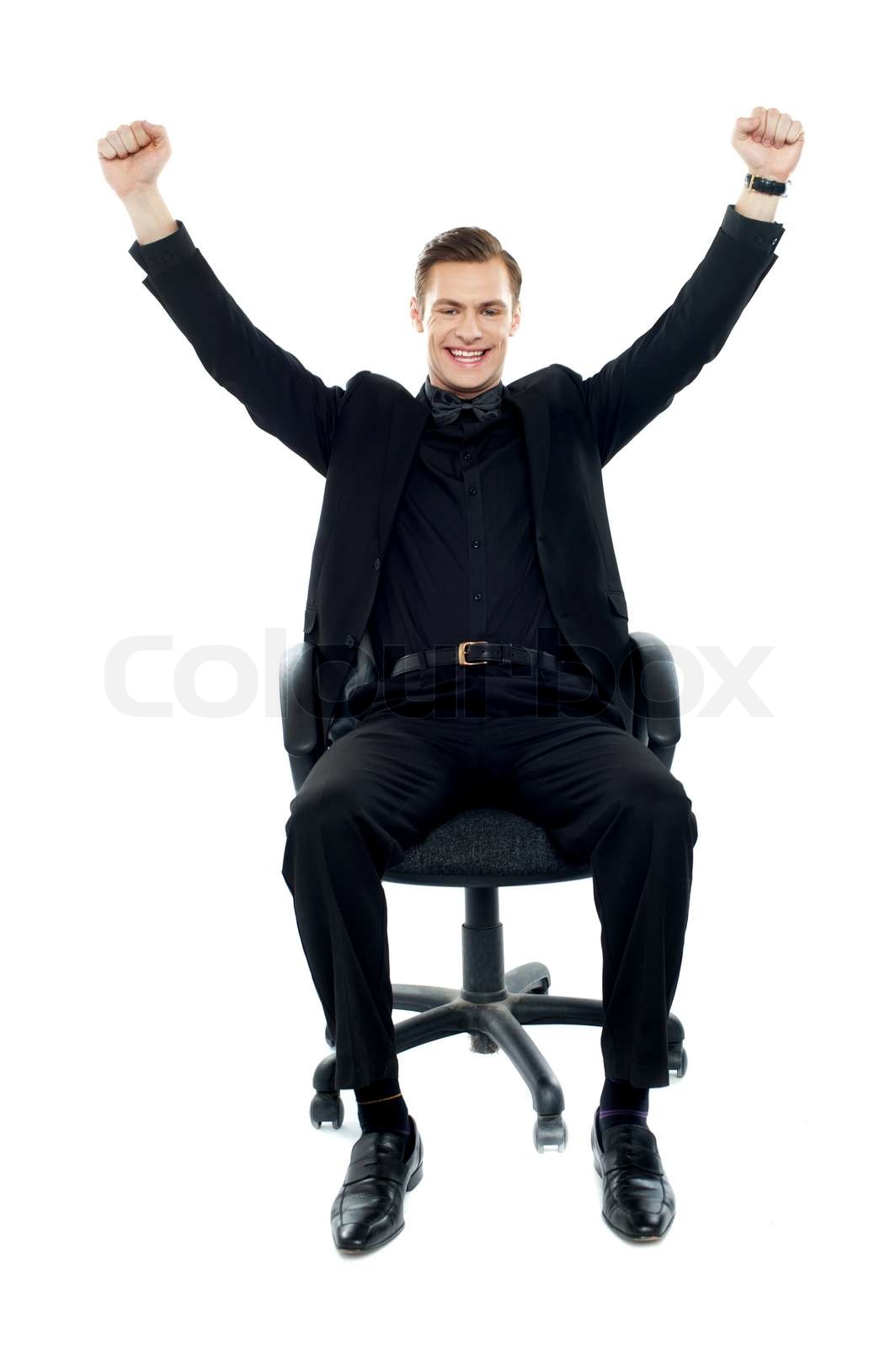 Excited young man sitting on chair | Stock image | Colourbox