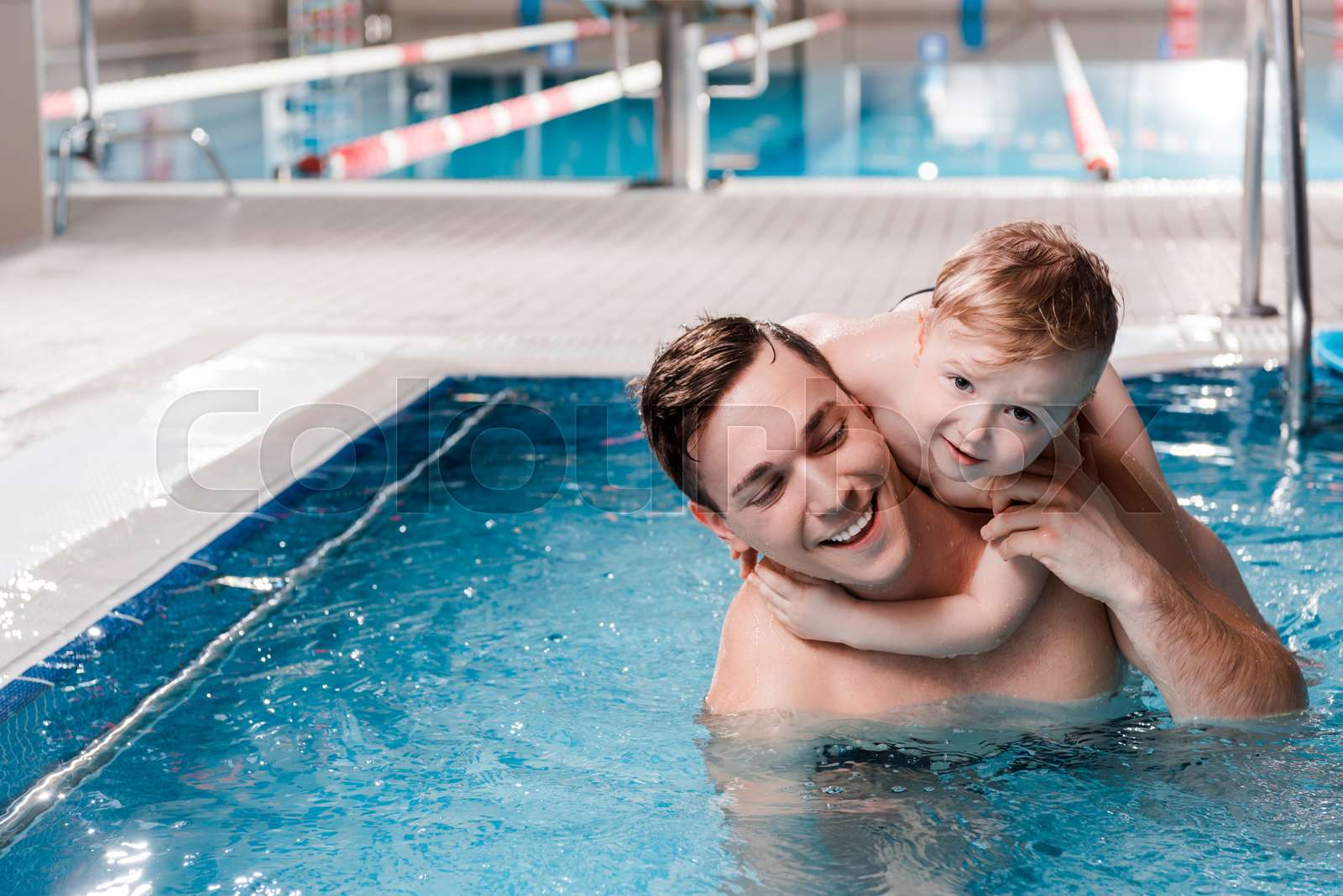 happy toddler kid hugging swim coach in swimming pool | Stock image ...