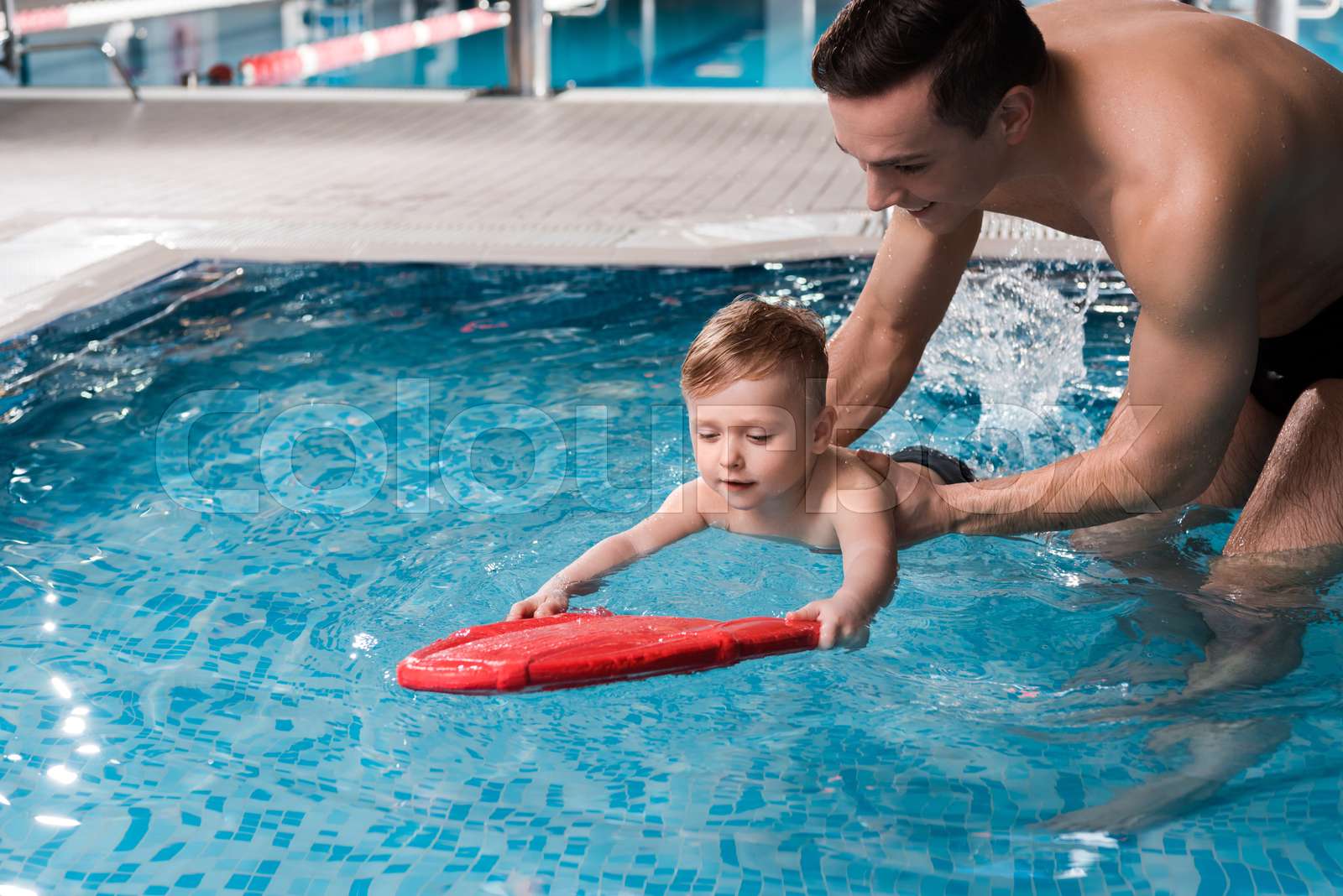 happy swim coach teaching toddler kid with flutter board in swimming ...